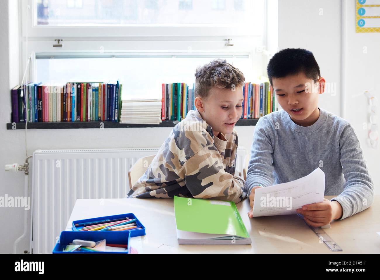 Boy students working together in classroom Stock Photo - Alamy