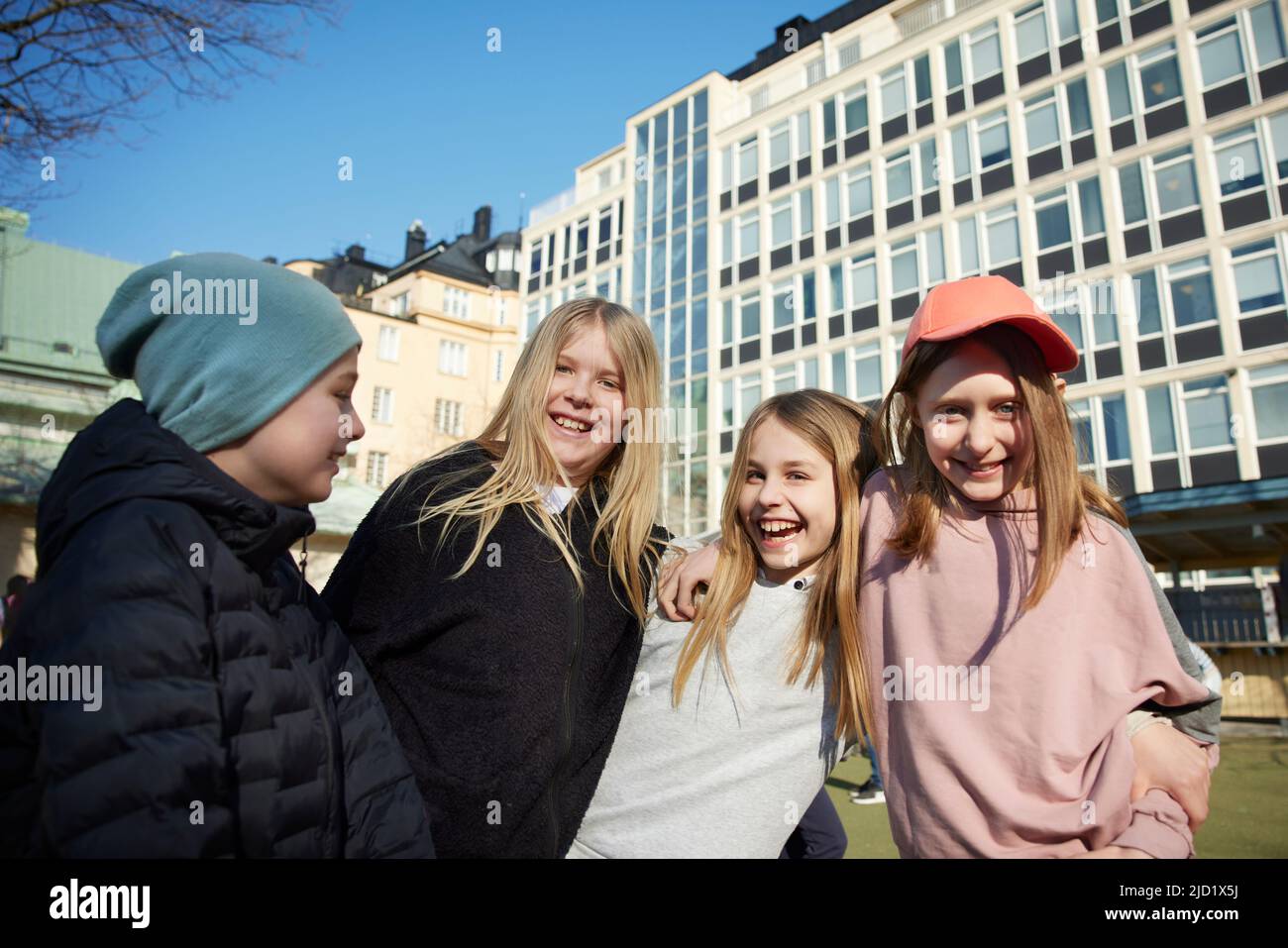 Portrait of smiling friends in front of school Stock Photo - Alamy