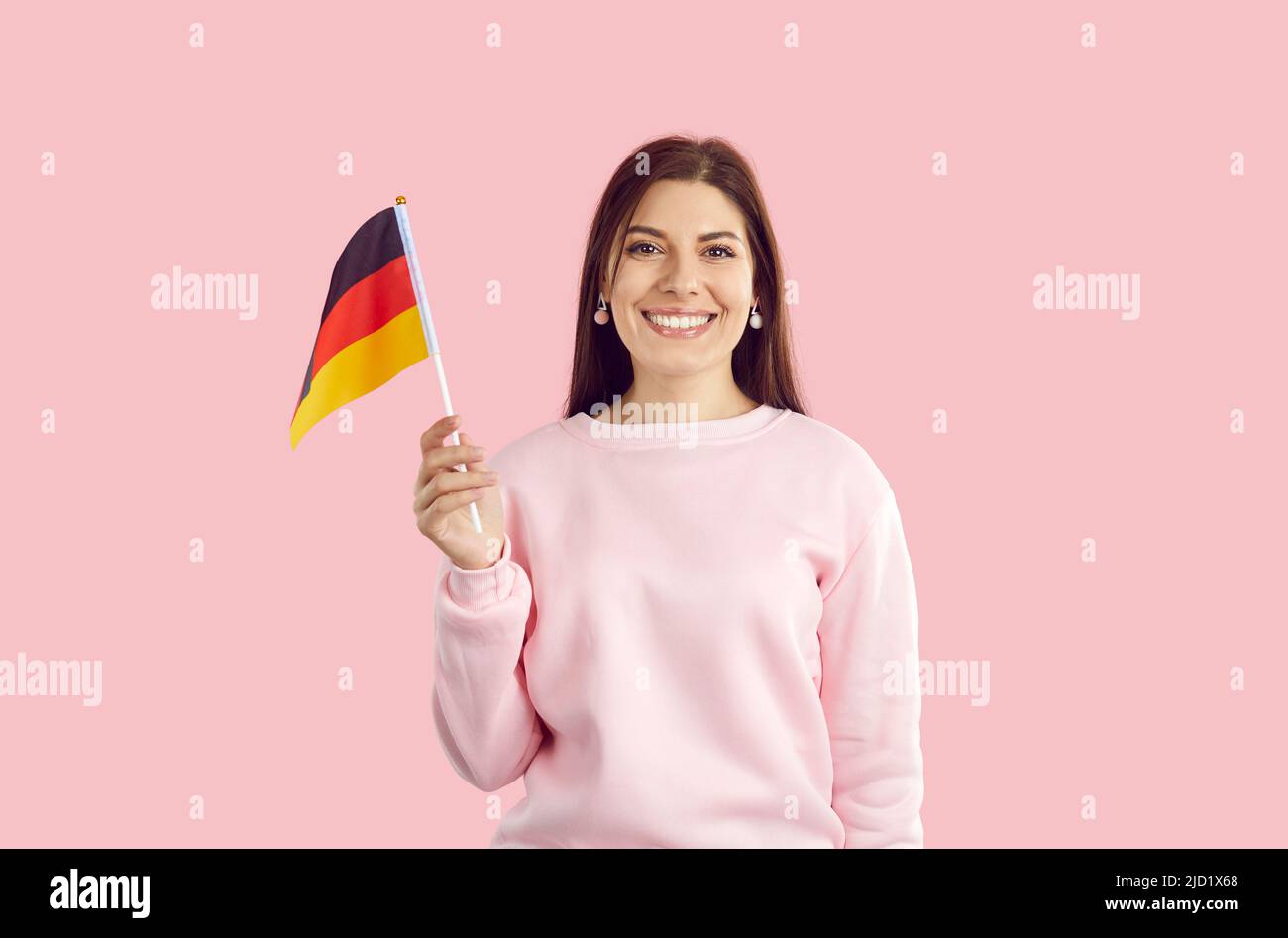 Studio portrait of happy smiling woman waving small German flag on ...