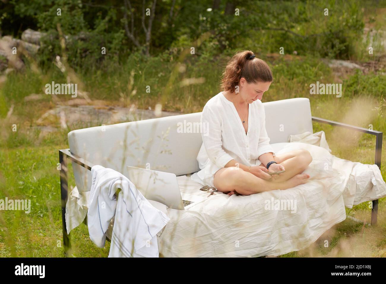 Woman sitting on garden bench Stock Photo - Alamy
