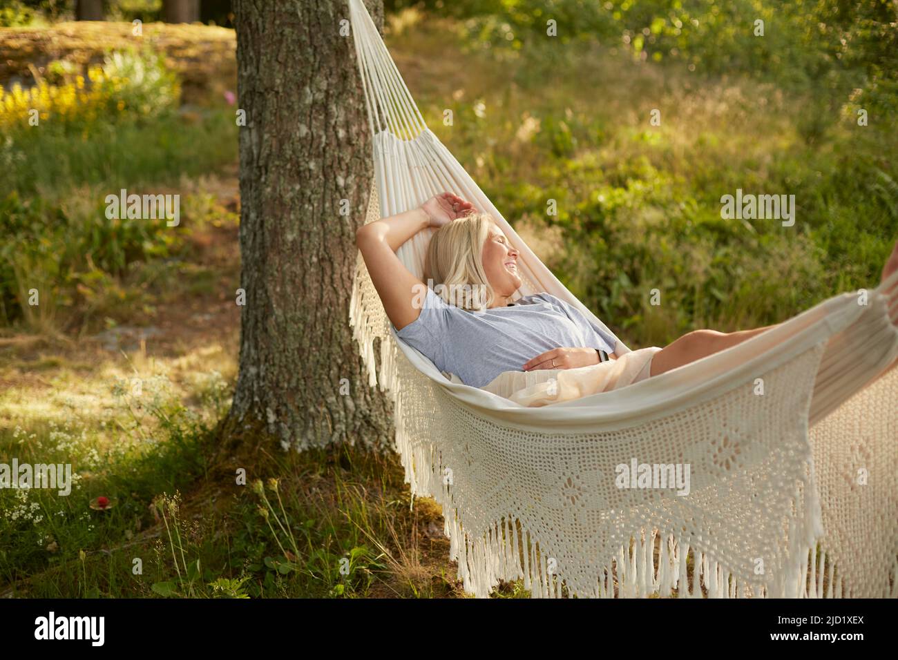 Smiling woman at home lying in hammock hi-res stock photography and ...