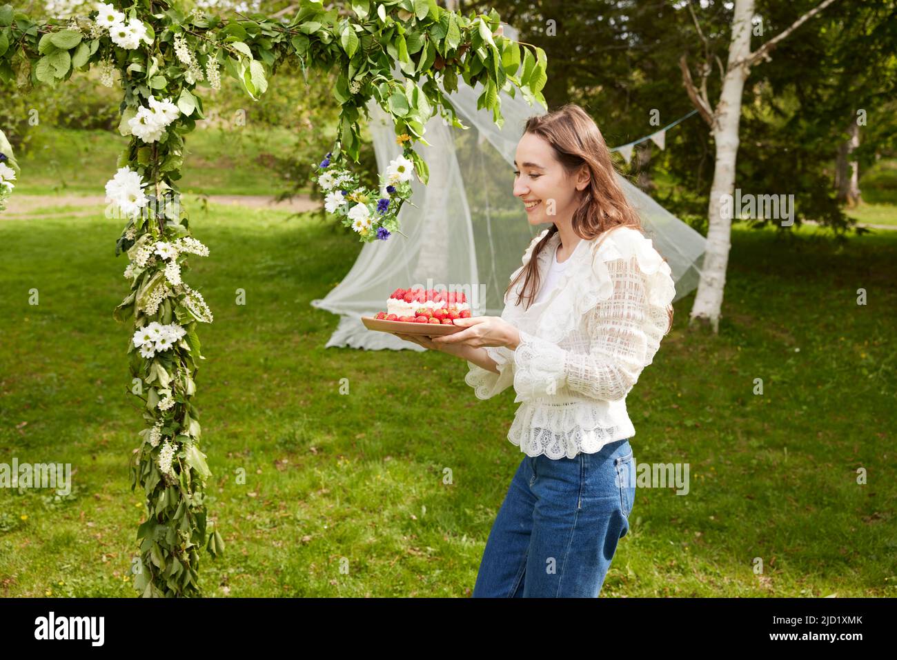 Woman carrying cake outdoors Stock Photo - Alamy