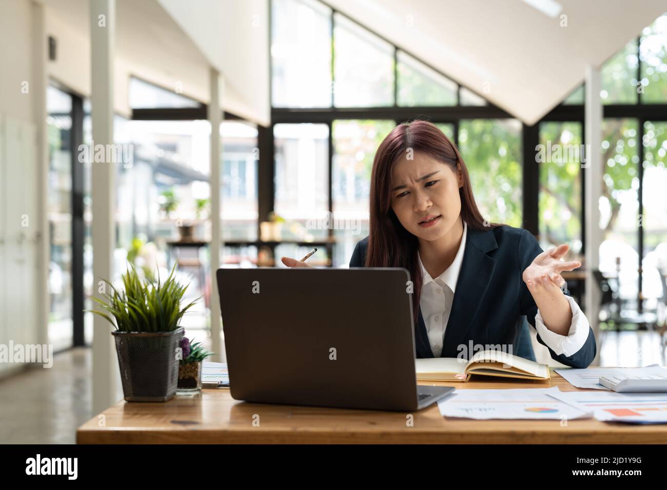 Young stressed businesswoman working at desk in modern office shouting ...