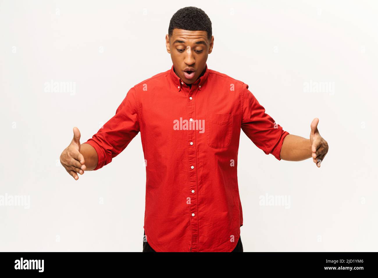 Shocked latin man posing over white background gesturing with hands and ...