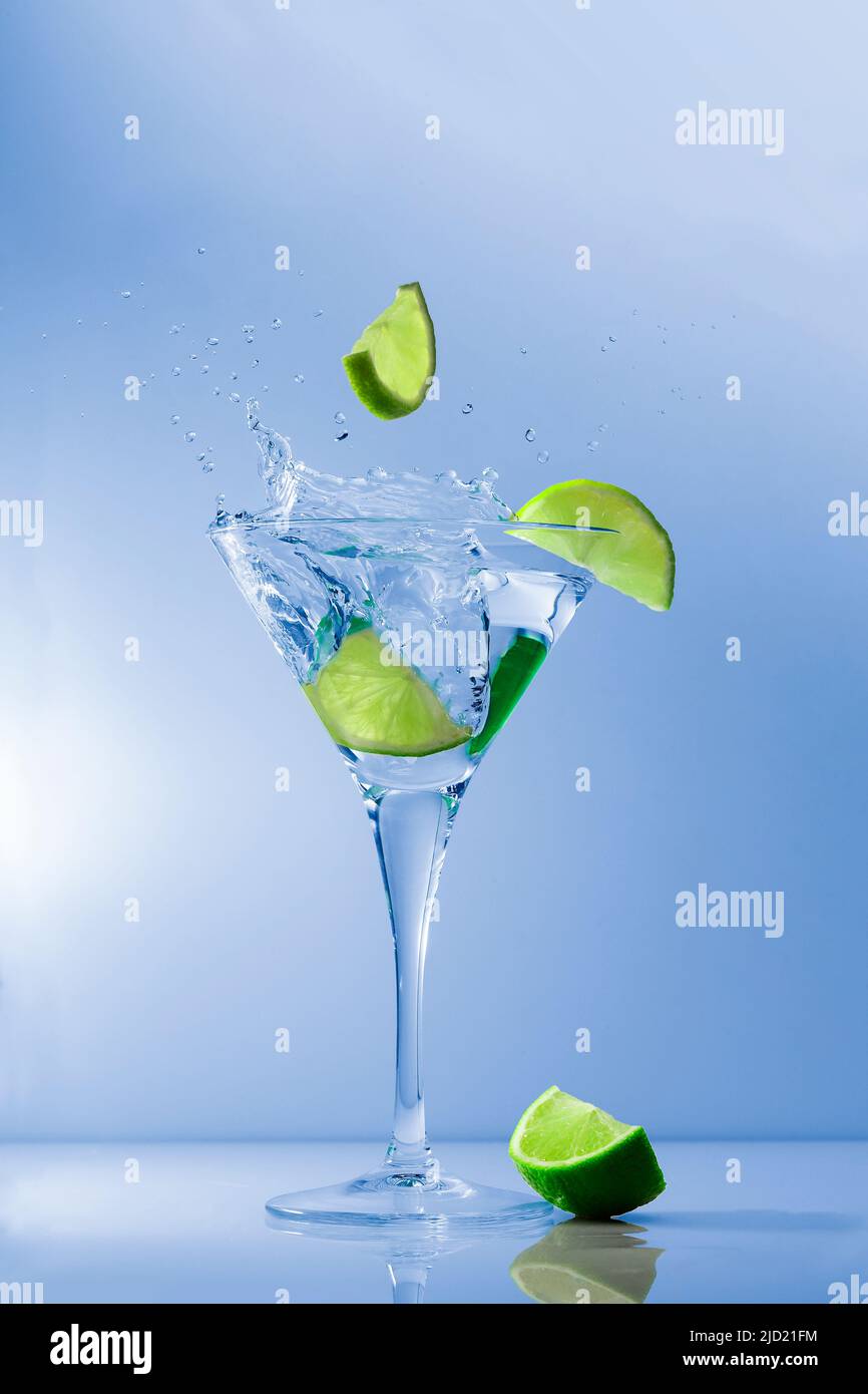 cocktail drink with splashing lime slices Stock Photo - Alamy