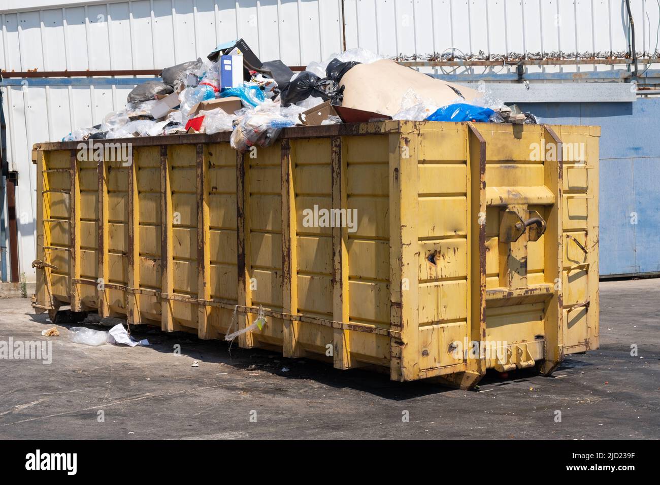 Huge Big Overloaded dumpster waste container filled with waste near the ...