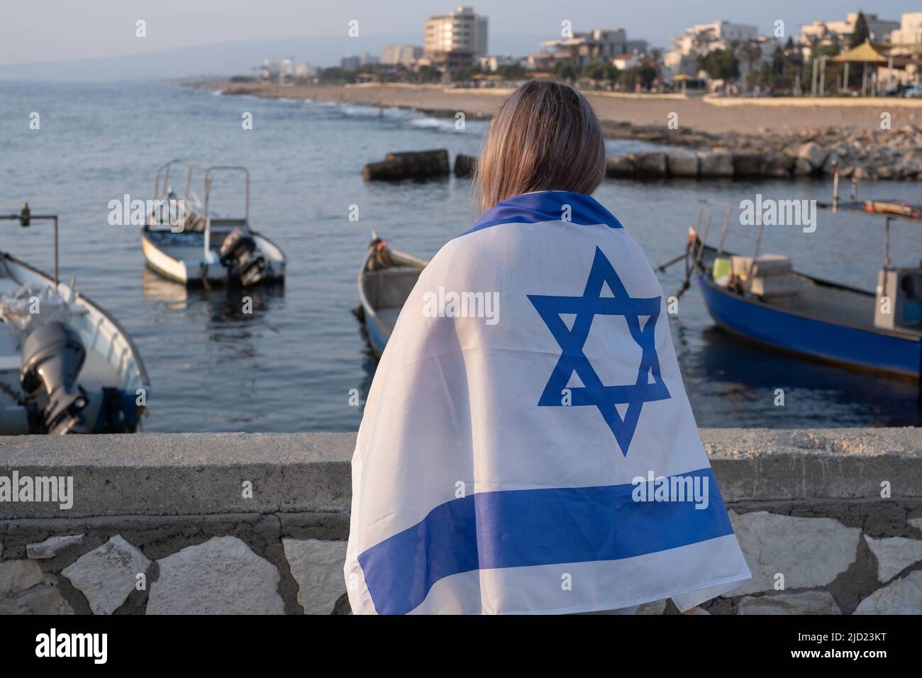 Teen woman with the Flag of Israel draped over her shoulders. Female ...