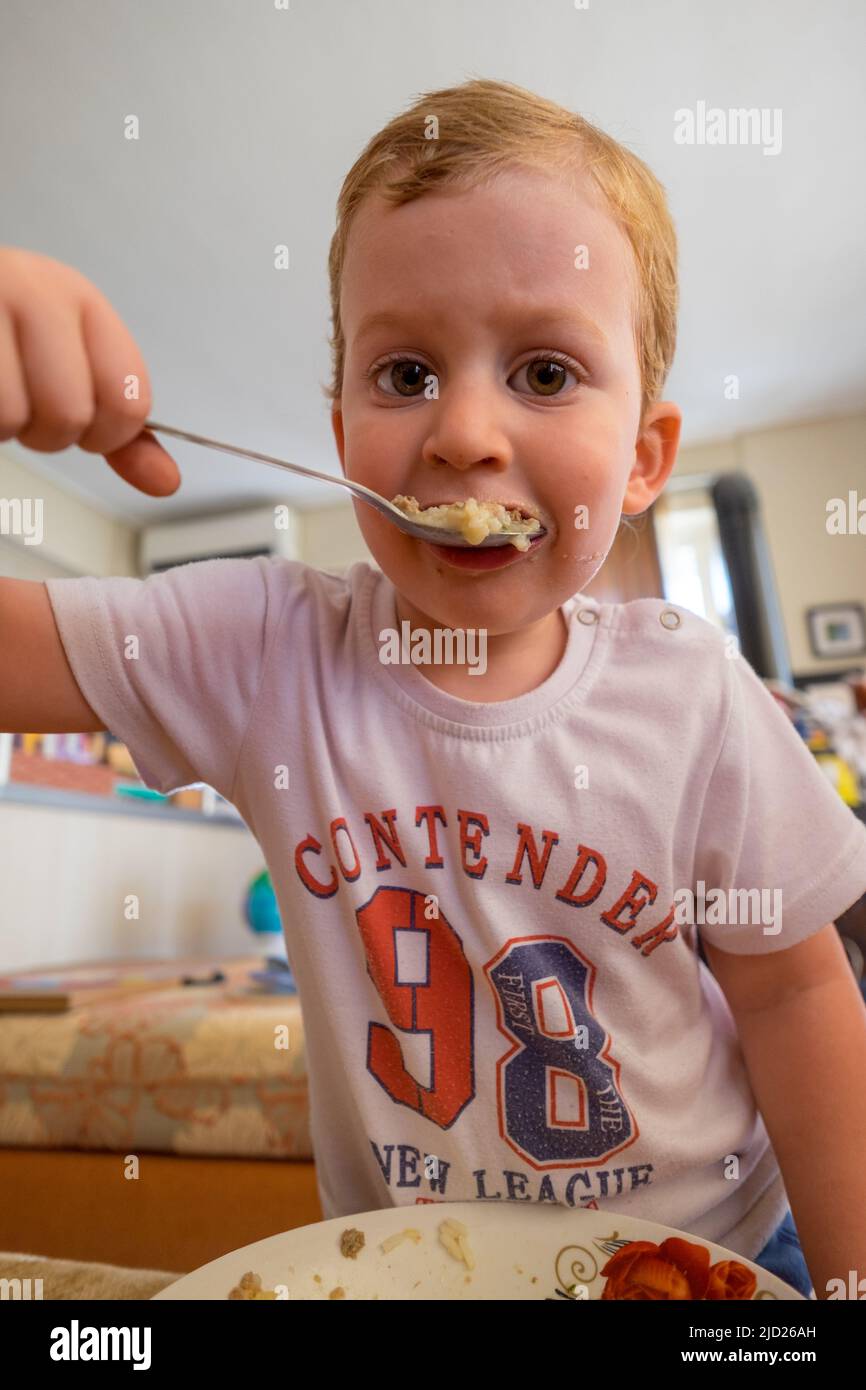 Cute little boy eating his meal Stock Photo - Alamy