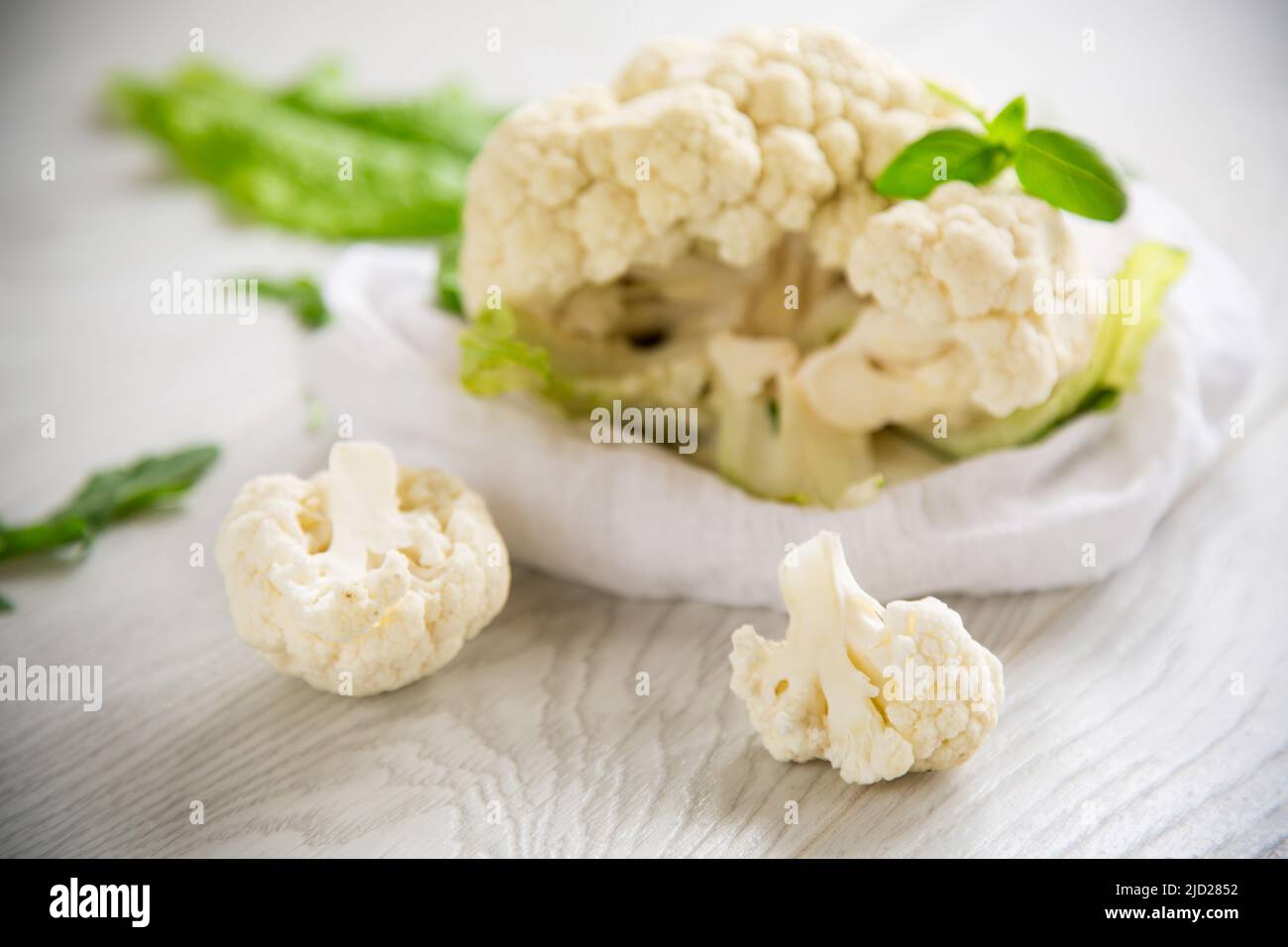 inflorescences of small raw cauliflower on a light wooden table Stock ...