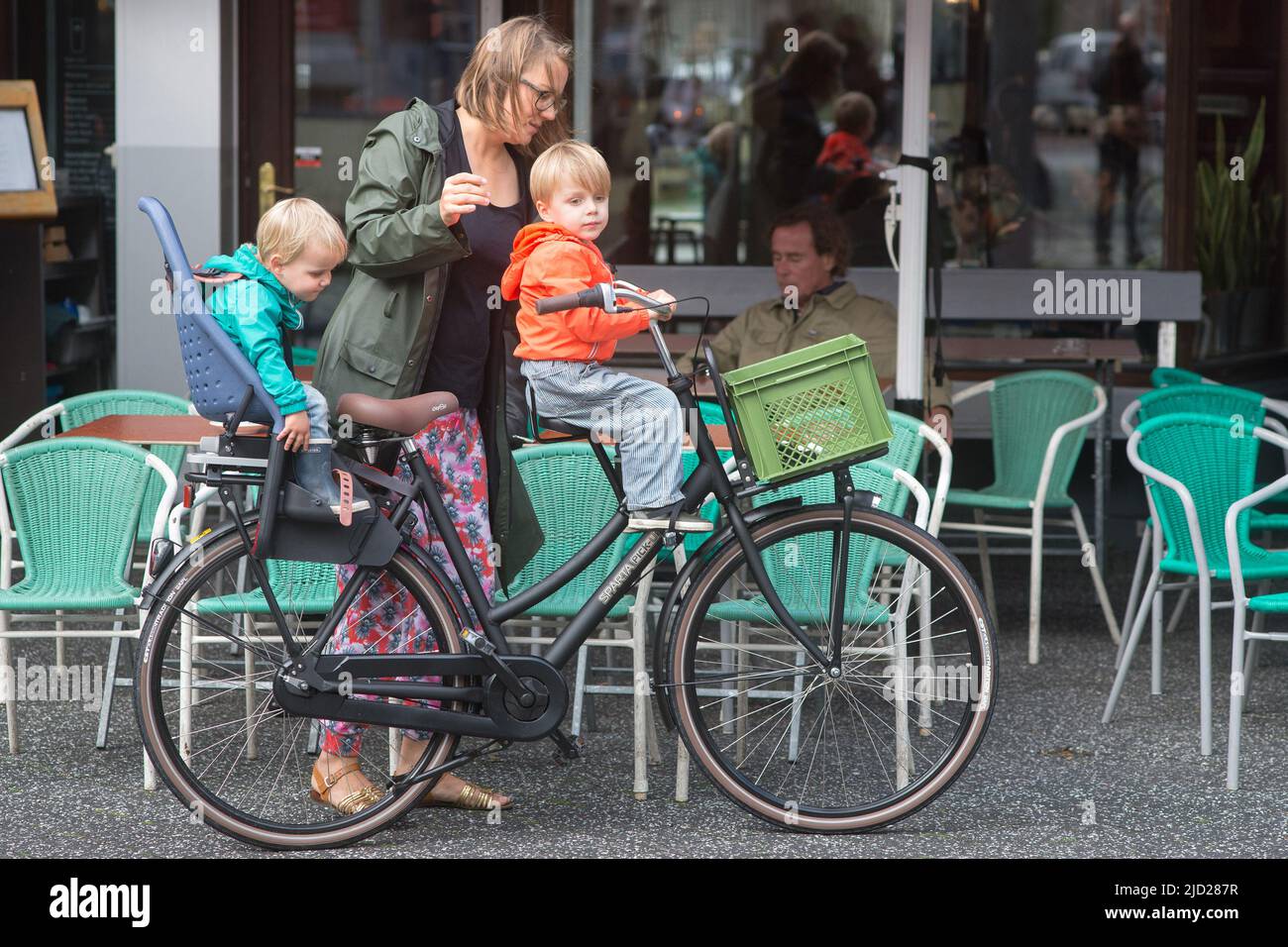 Amsterdam, Holland: A young mother places her two young children in the ...