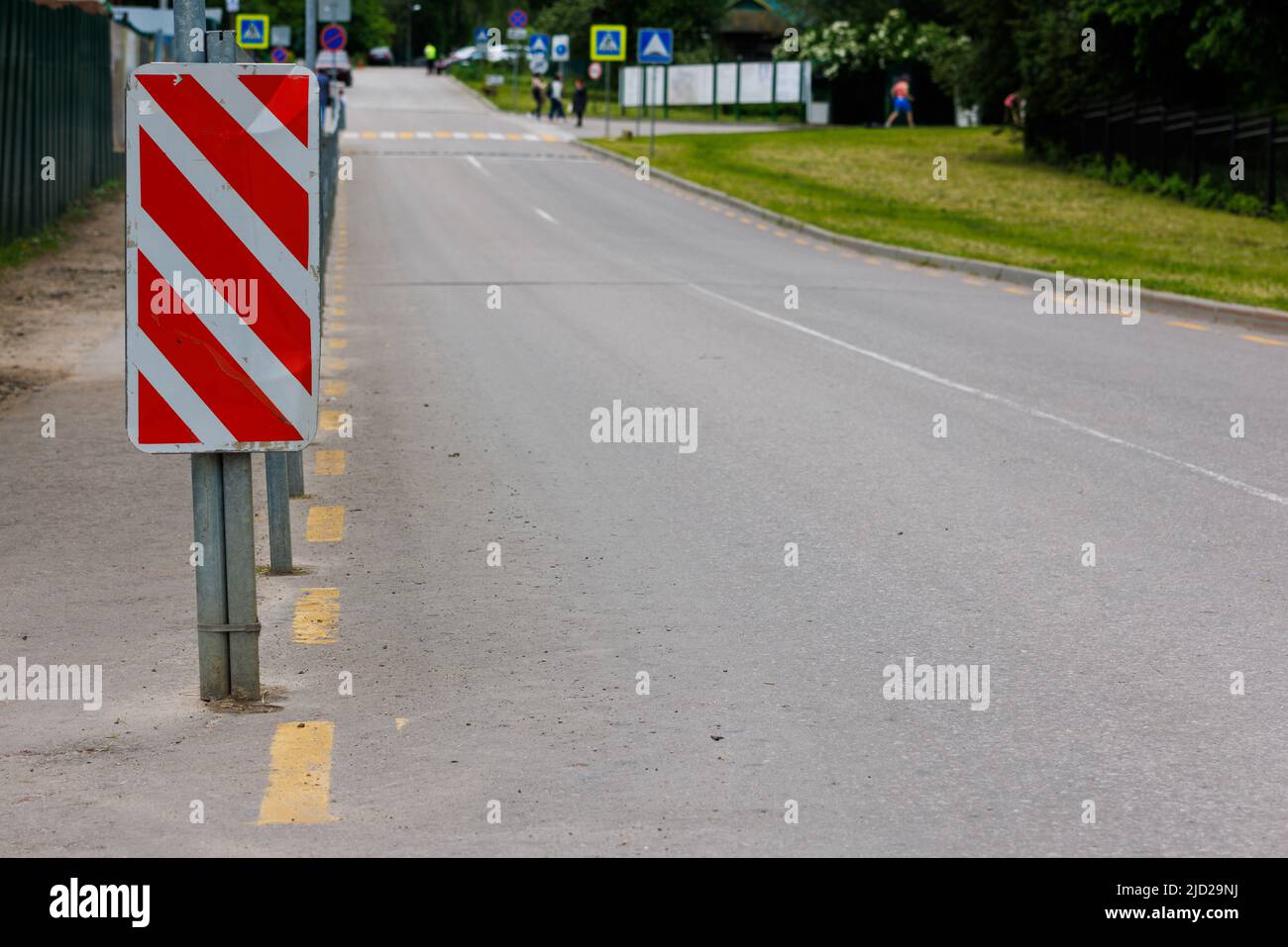 red and white diagonal striped sign at road fence end Stock Photo - Alamy