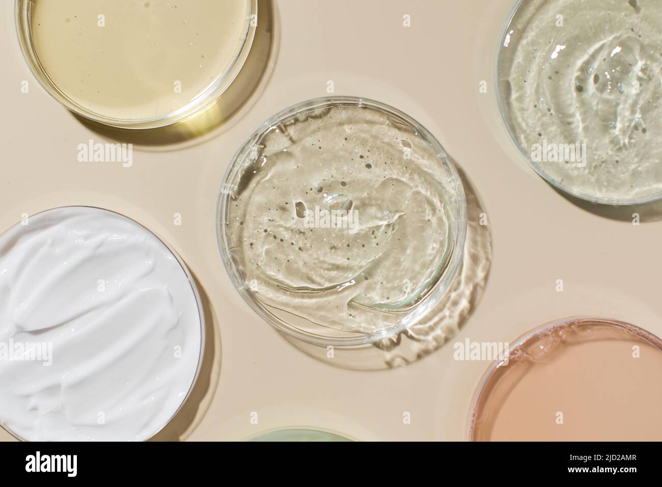 Various cosmetic products in Petri dishes on beige background view from ...