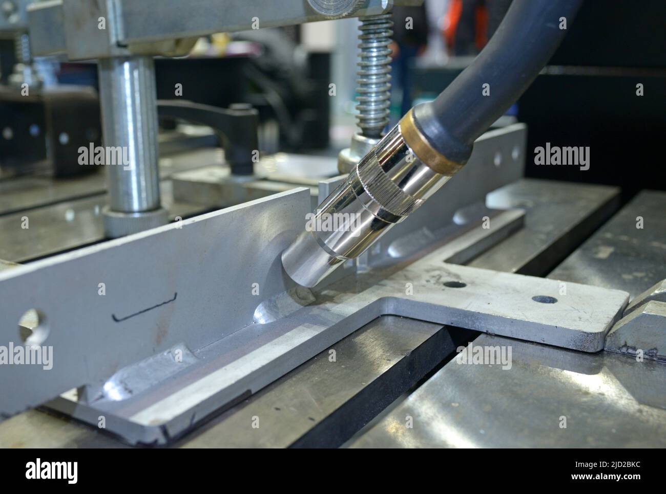 MIG welding torch of a robot working making weld on piece of metal ...
