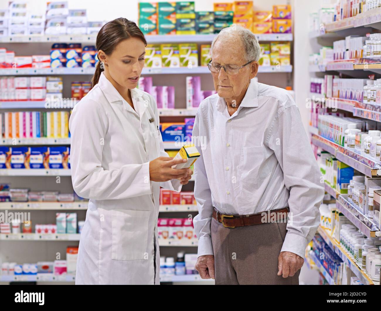 Each and every client is special. Shot of a young pharmacist helping an ...
