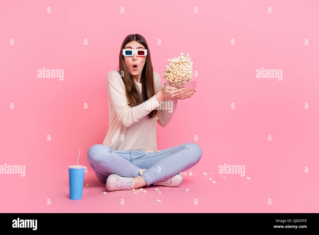 Portrait of attractive amazed girl sitting on floor watching video ...
