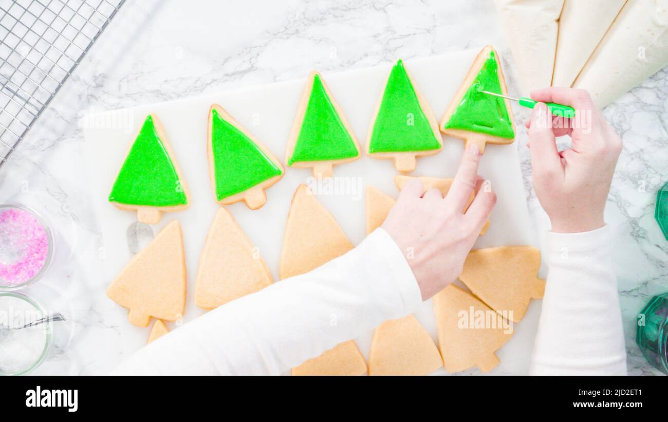 Flat lay. Stp by step. Icing Christmas tree-shaped sugar cookies with ...