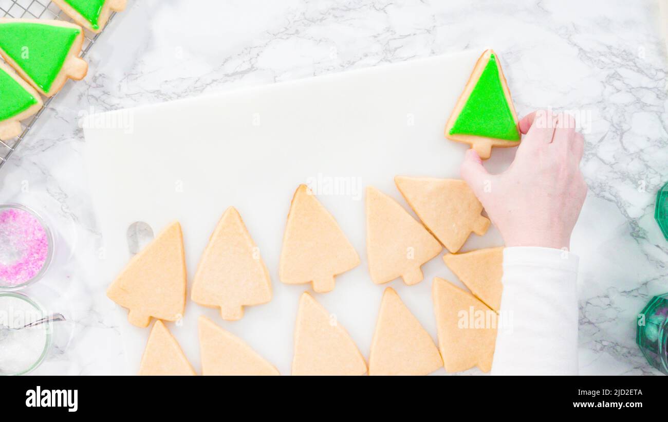 Flat lay. Stp by step. Icing Christmas tree-shaped sugar cookies with ...