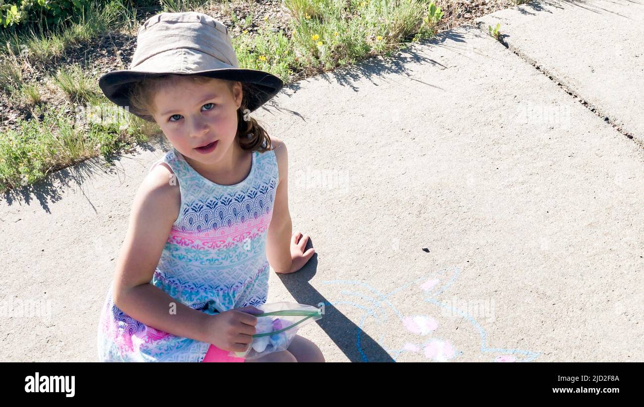 Little girl drawing with chalk on a sidewalk on the summer day Stock ...