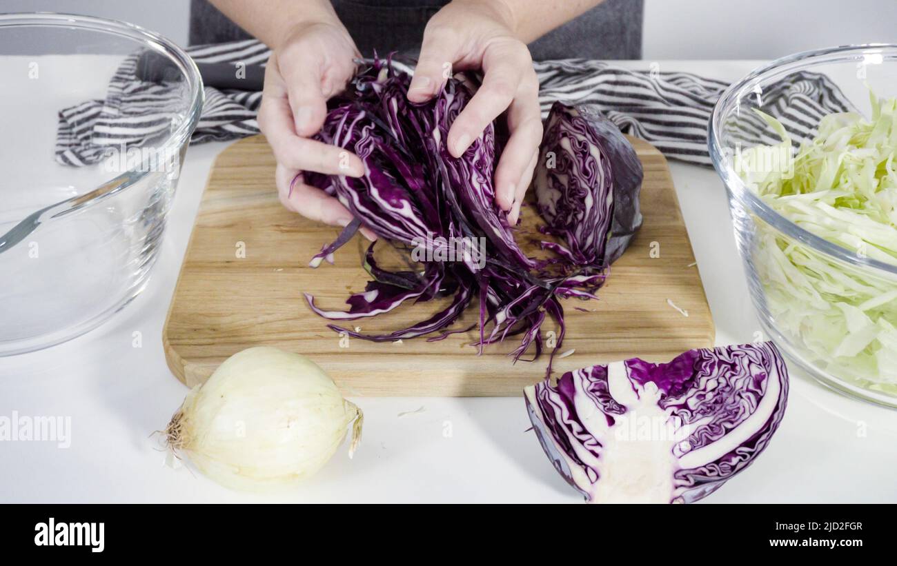 Step by step. Shredding organic cabbage on a wood cutting board Stock ...