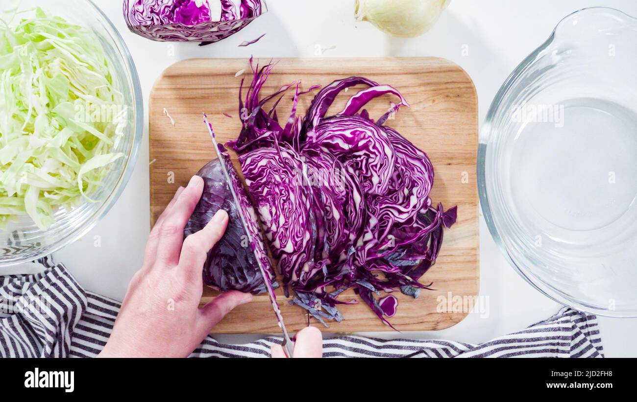 Flat lay. Step by step. Shredding organic cabbage on a wood cutting ...
