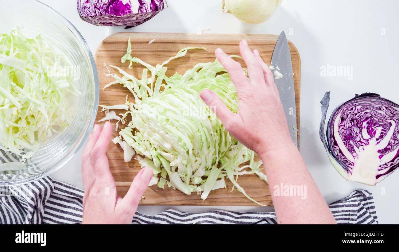 Flat lay. Step by step. Shredding organic cabbage on a wood cutting ...