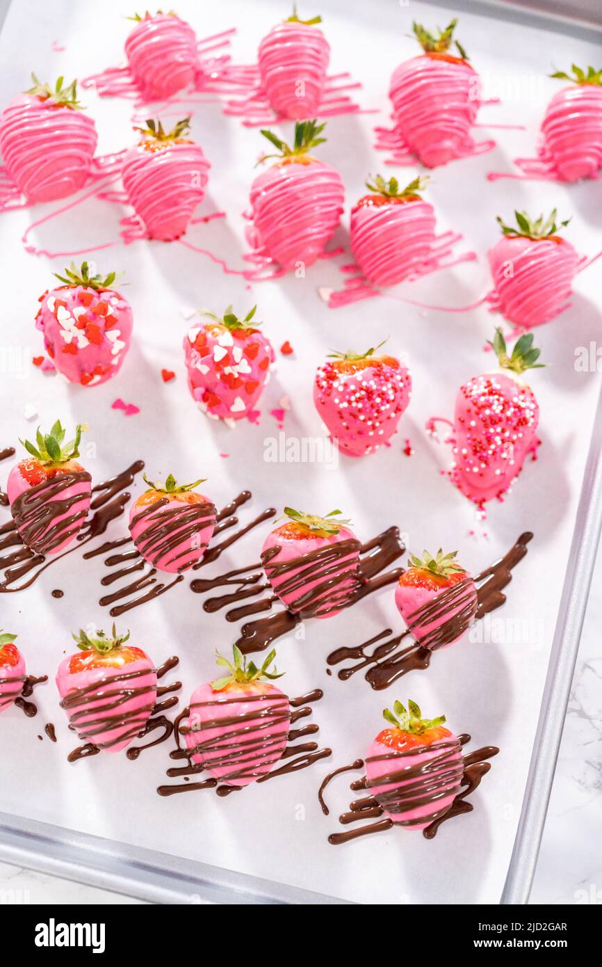 Decorating chocolate-covered strawberries with chocolate drizzles and ...