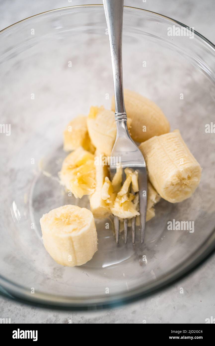 Mashing overhyped banana with a fork Stock Photo - Alamy
