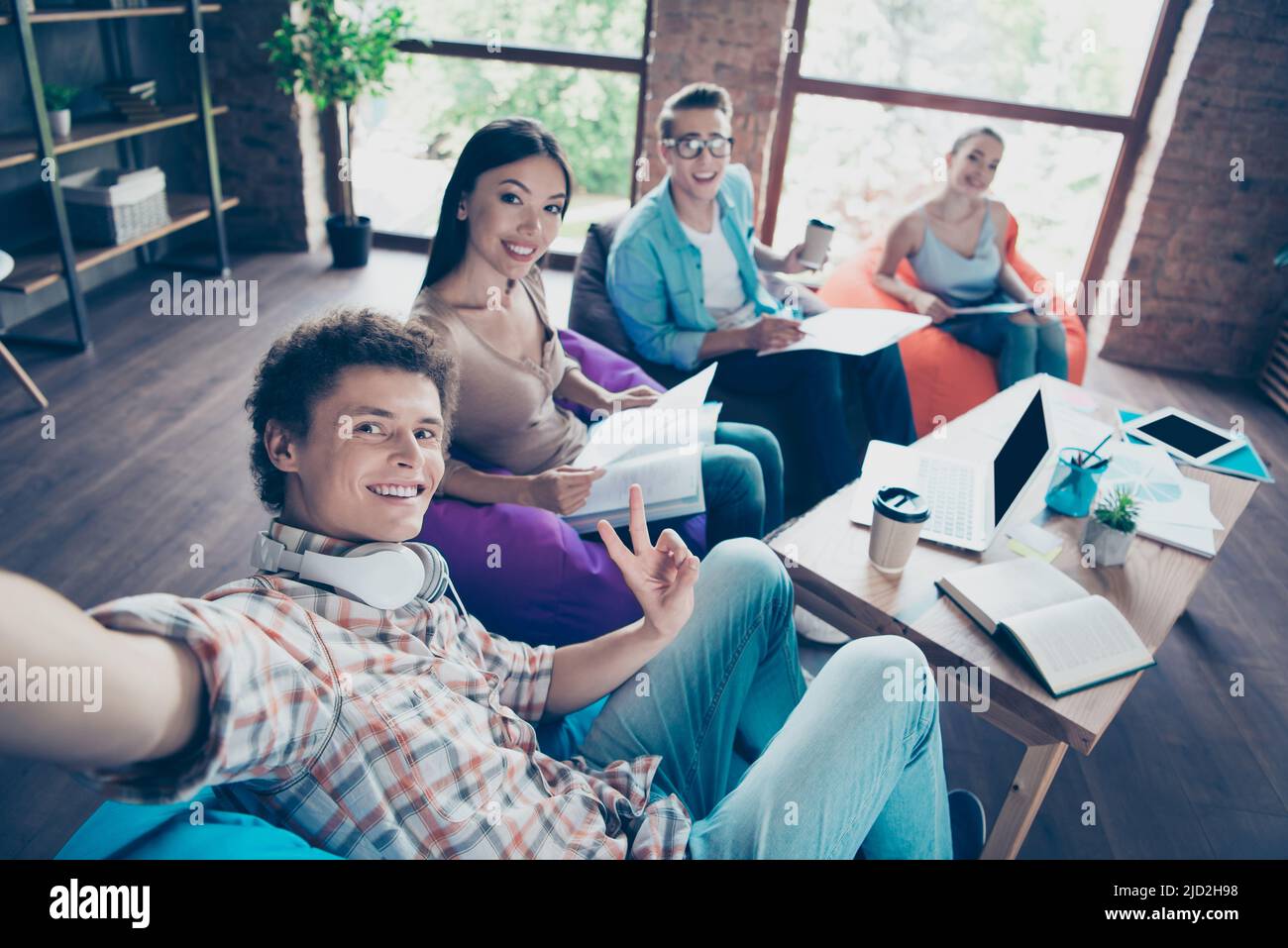 Photo of group friendly positive people sitting beanbag make selfie ...