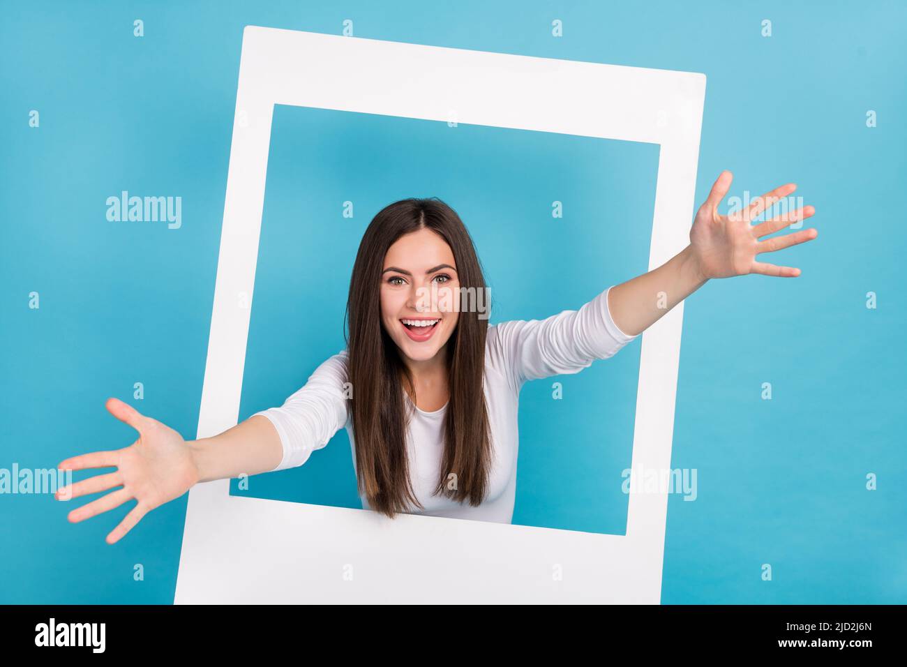 Portrait of attractive cheerful girl coming out of frame having fun ...