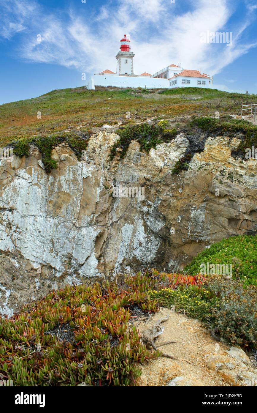 Lighthouse on top of a rock cliff and blue sky with clouds. Lisbon ...