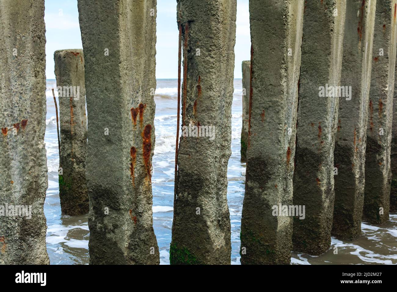 old groyne made of concrete piles close-up against the backdrop of a ...