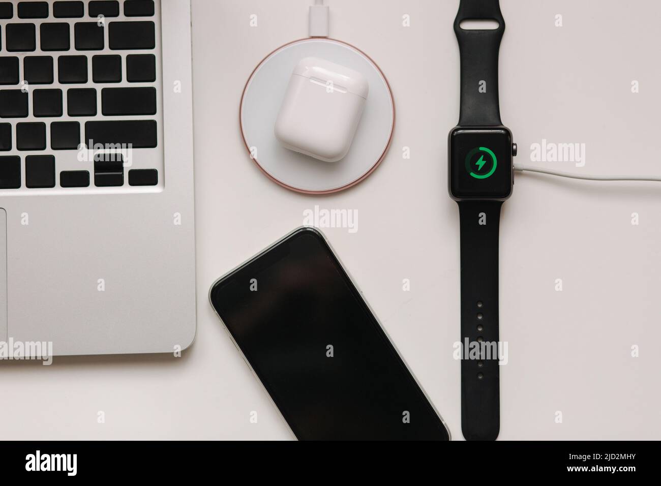 Working place with laptop on table and devices. Wireless charging of ...