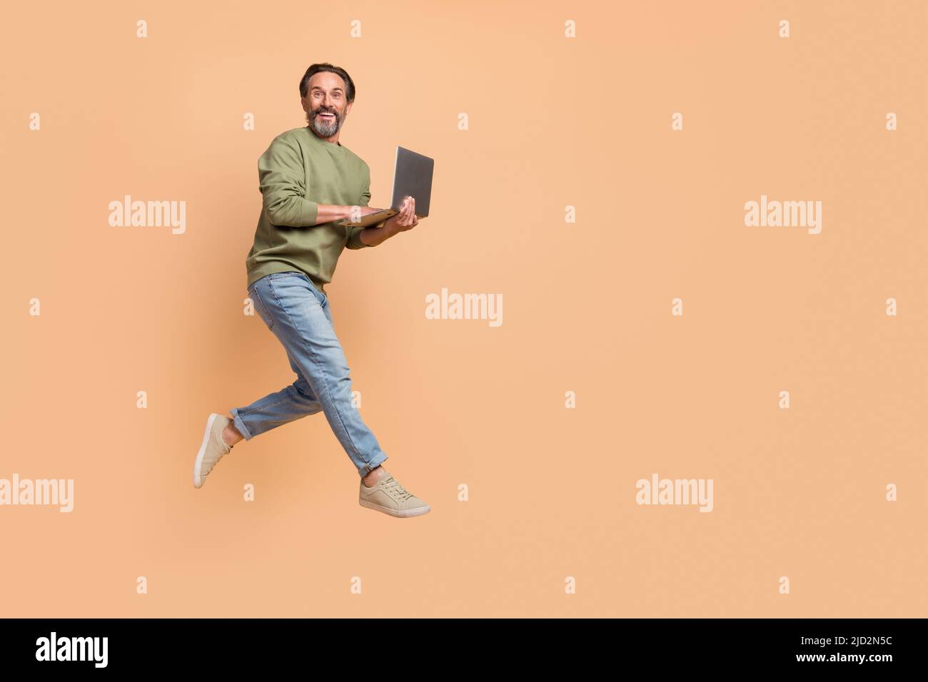 Full body profile portrait of energetic man hold use wireless netbook ...