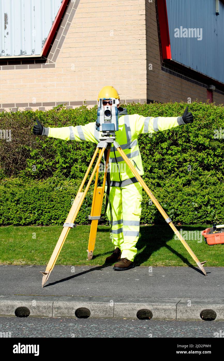 Site engineer giving an ok sign to another engineer during road survey ...
