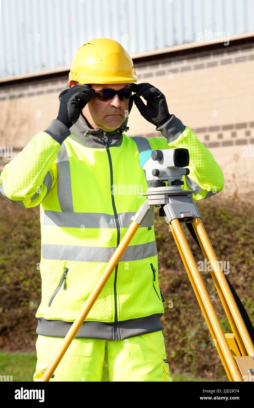 Site engineer checking levels of the road using autolevel Stock Photo ...
