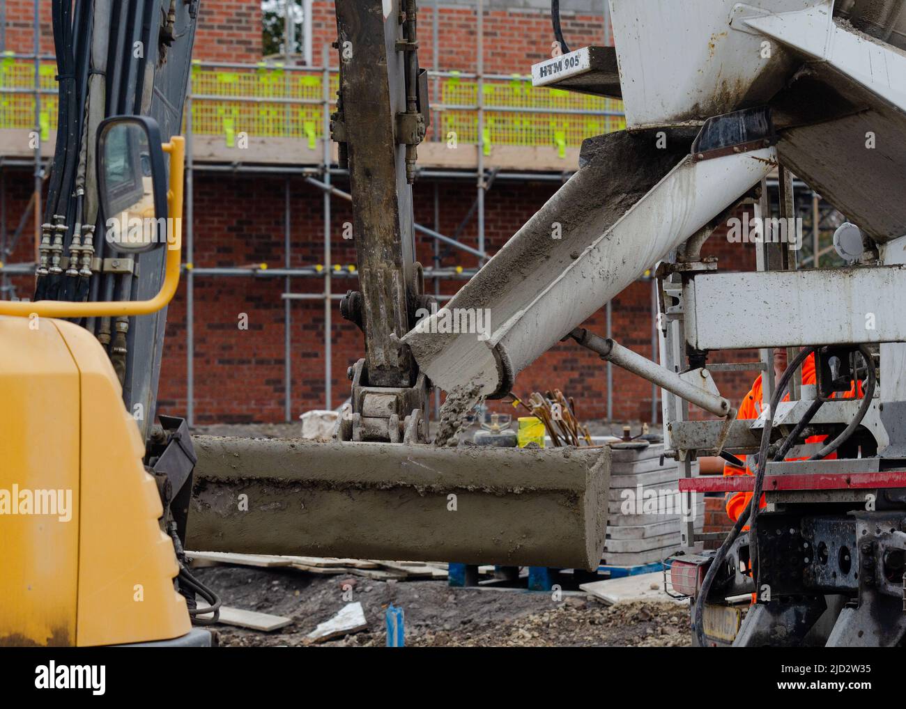 Exavator bucket filled with wet concrete to bring it to plce of ...