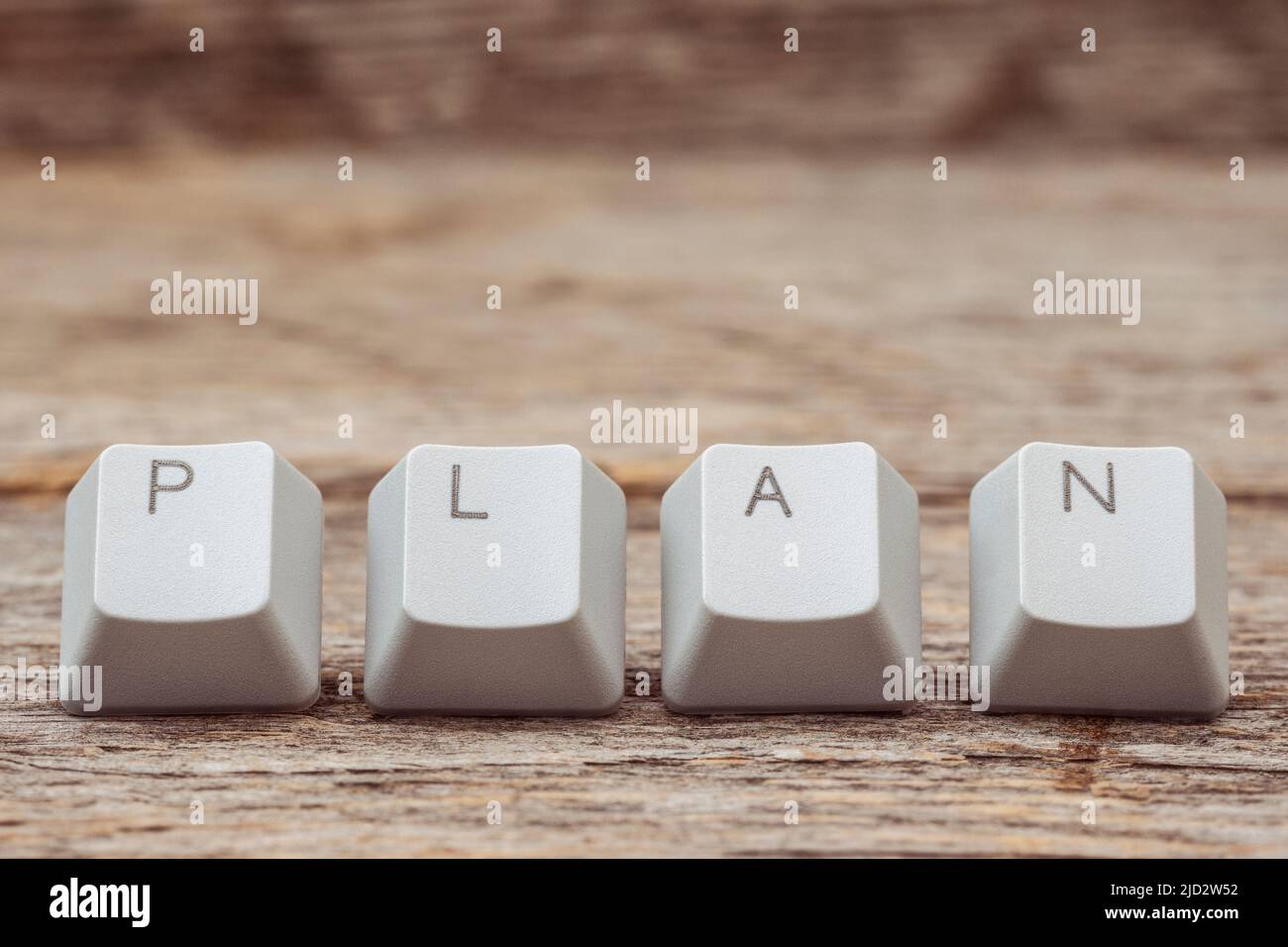 Computer keyboard keys arranged to spell PLAN word on the wooden ...
