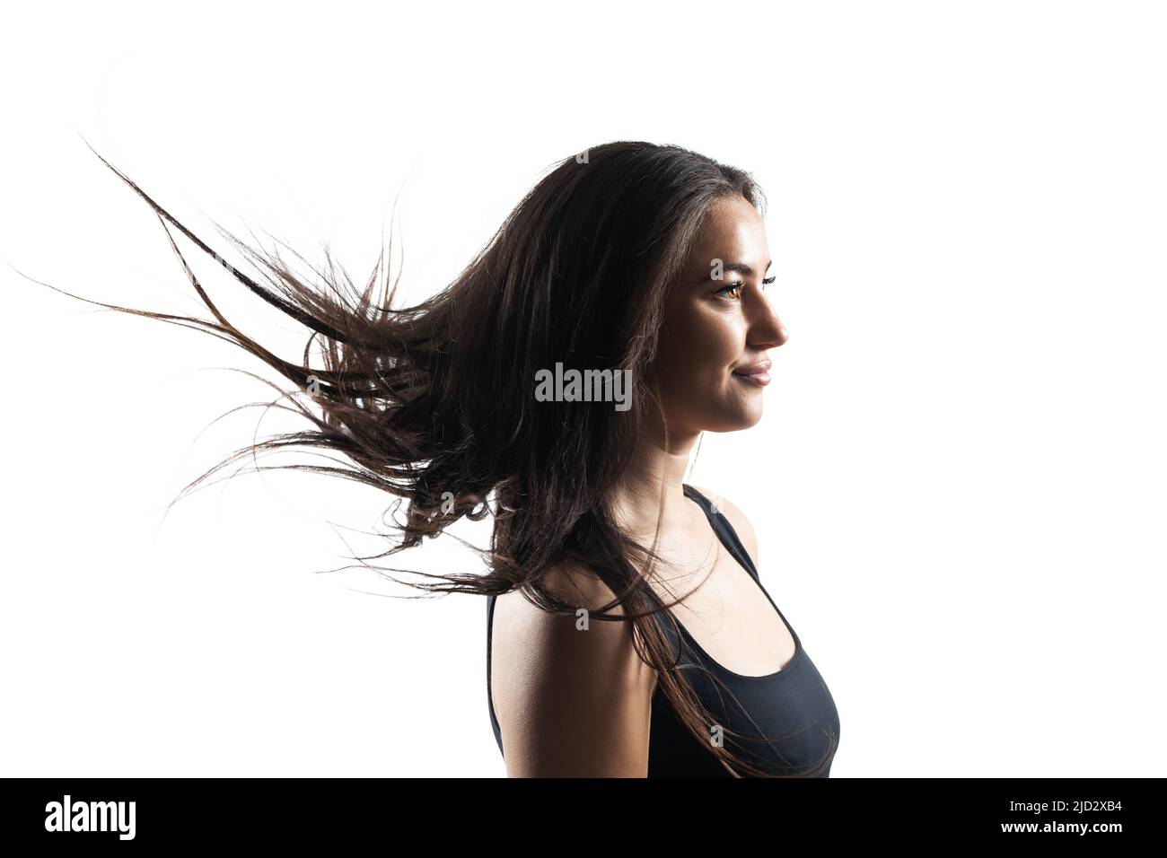 studio portrait of a beautiful brunette girl with flowing hair against ...