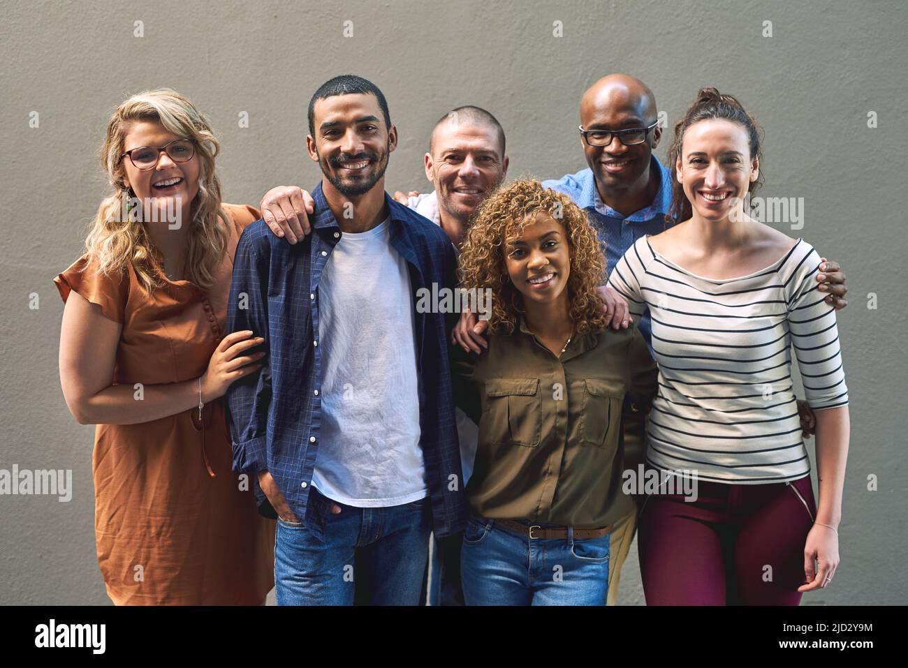Friends all grouped together. Shot of a group cheerful friends standing ...