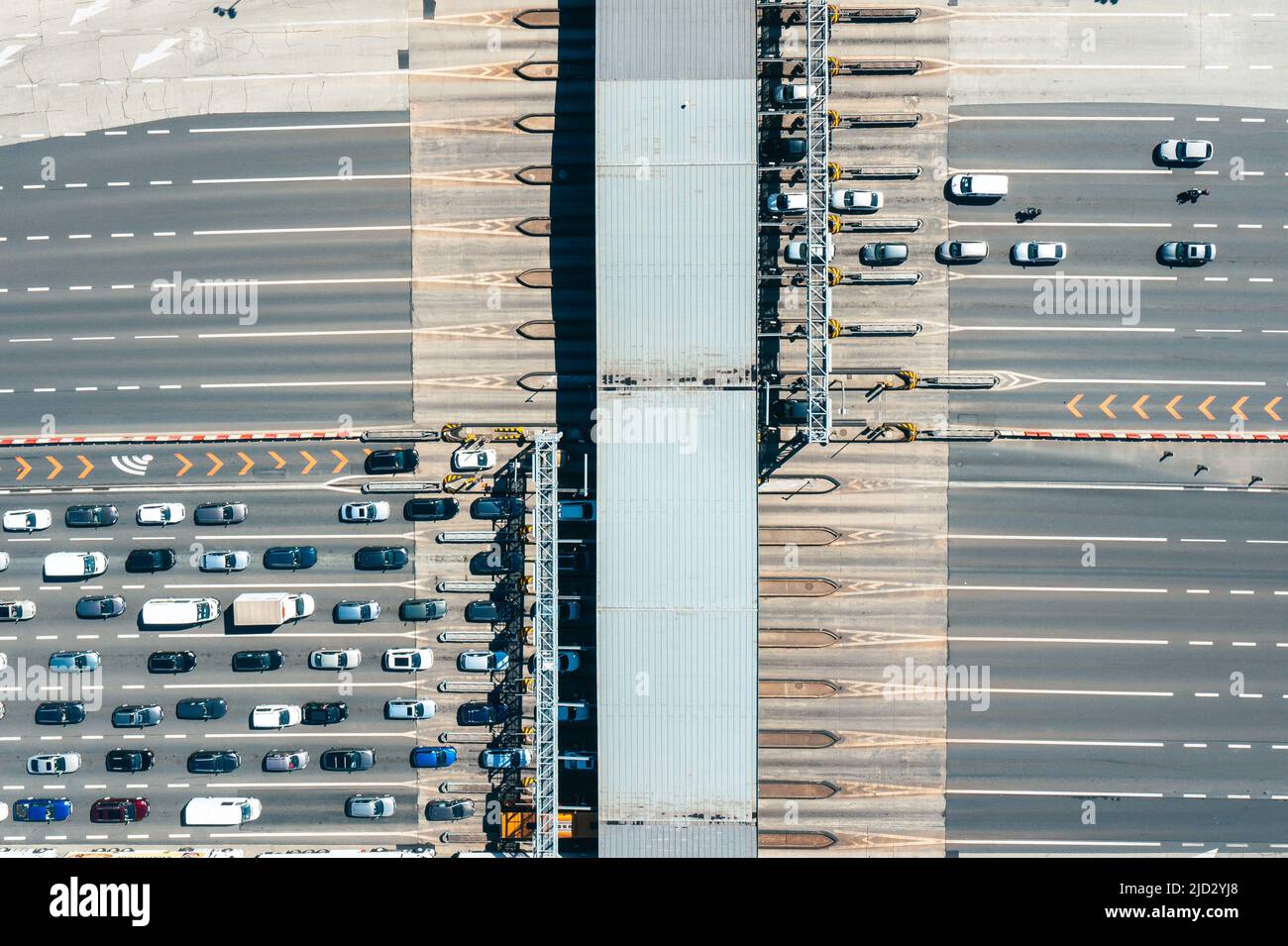 An overhead view of a busy toll road with many cars queuing up to pay ...