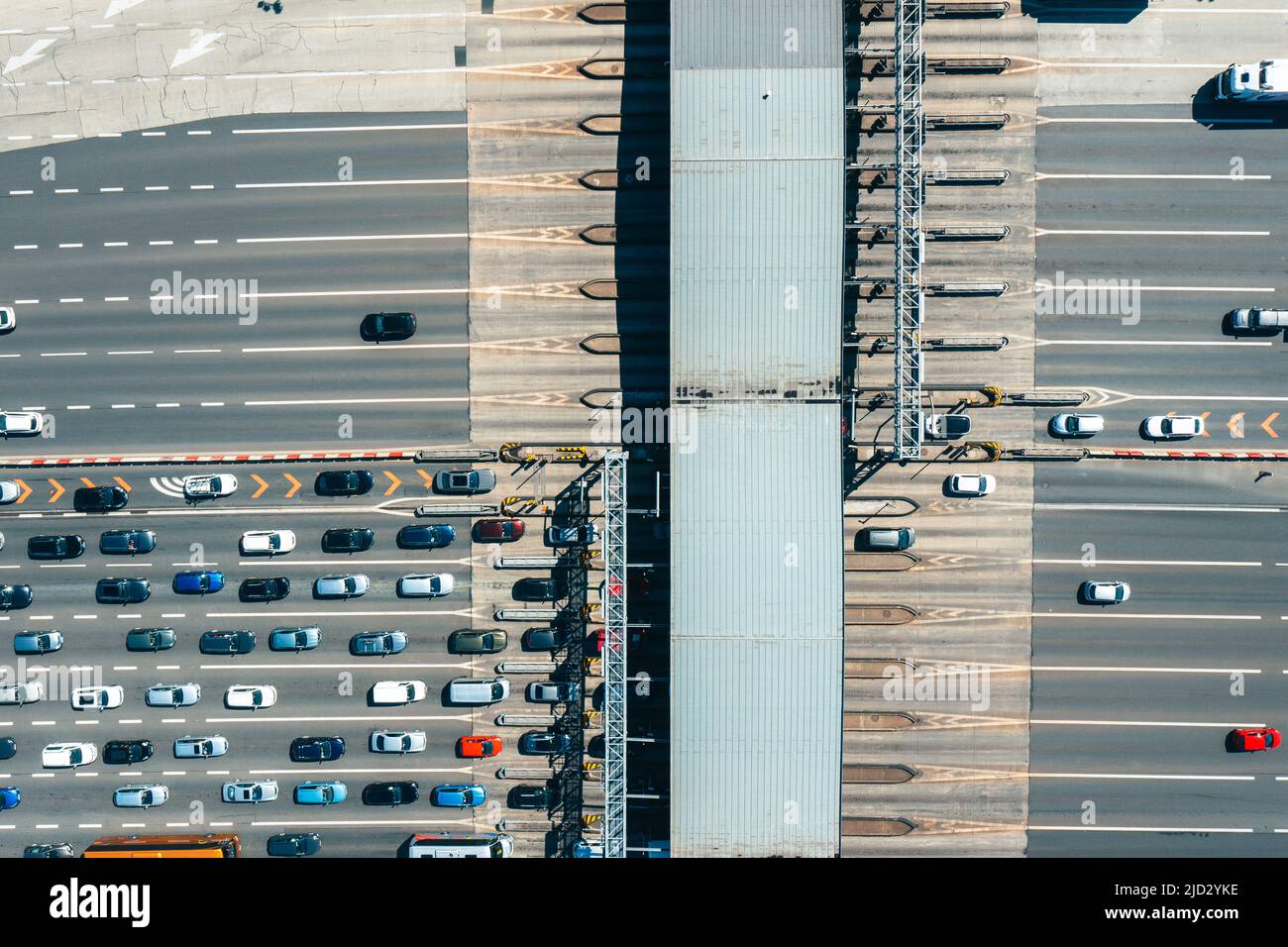 An overhead view of a busy toll road with many cars queuing up to pay ...