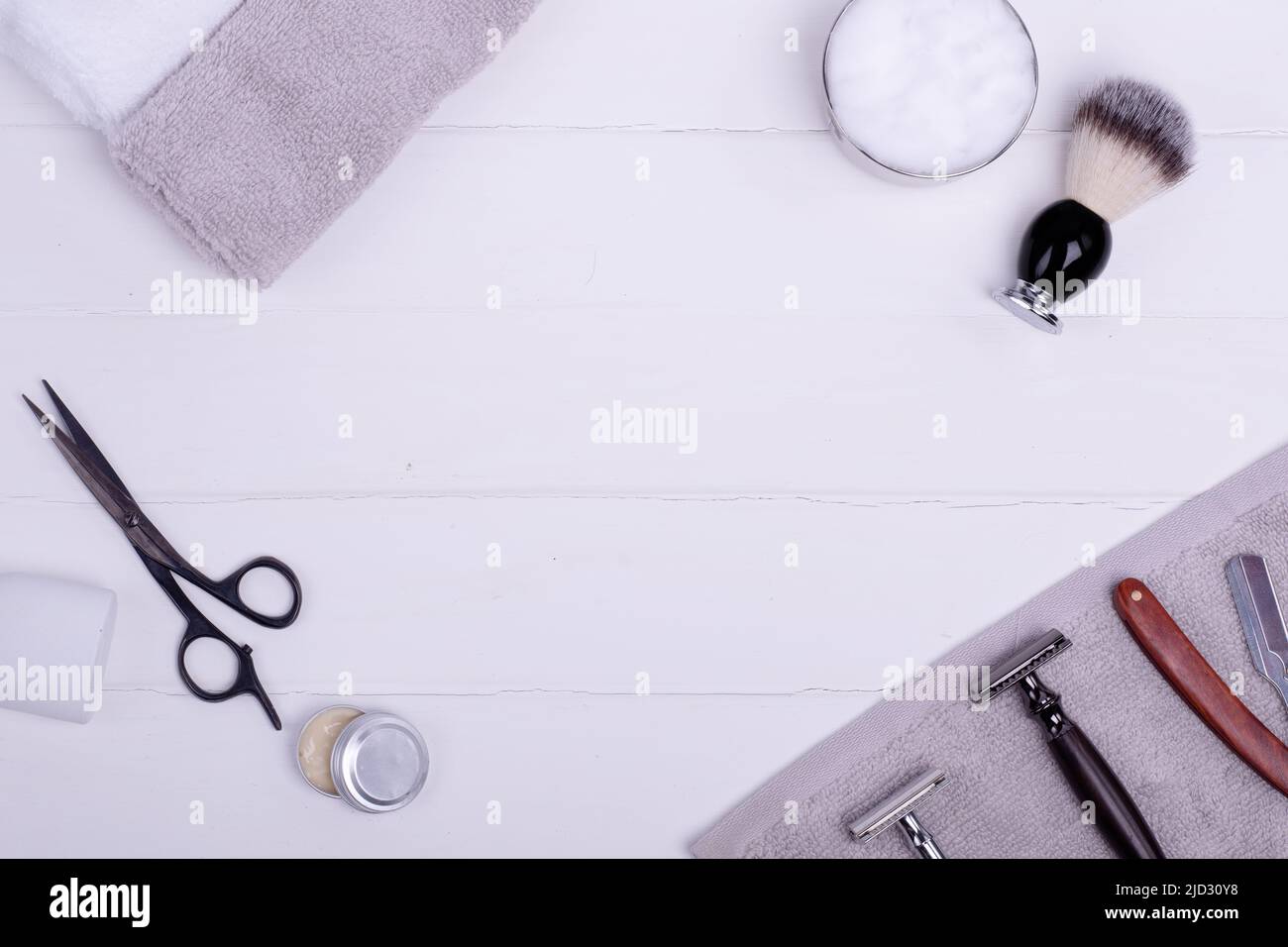 Different old vintage razors, foam, towels, scissors and brush on a ...