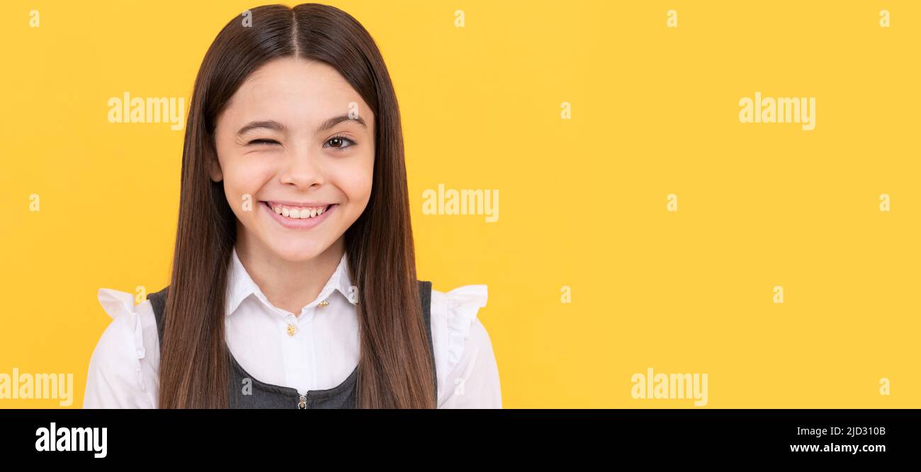 Happy school age girl child with smiling face give wink yellow ...