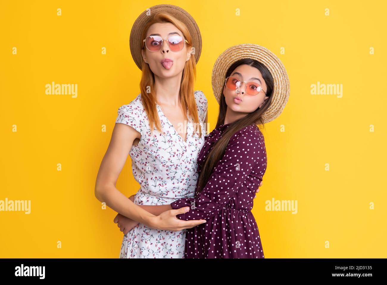 positive mom and daughter in straw hat on yellow background Stock Photo ...