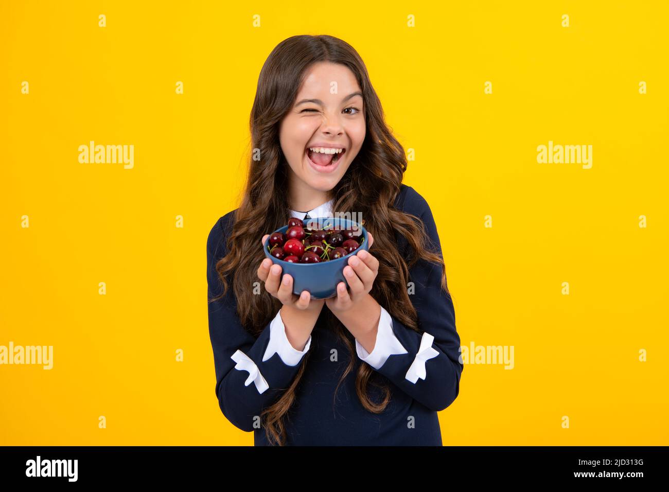 Teenager child girl hold plate cherries isolated on yellow background ...