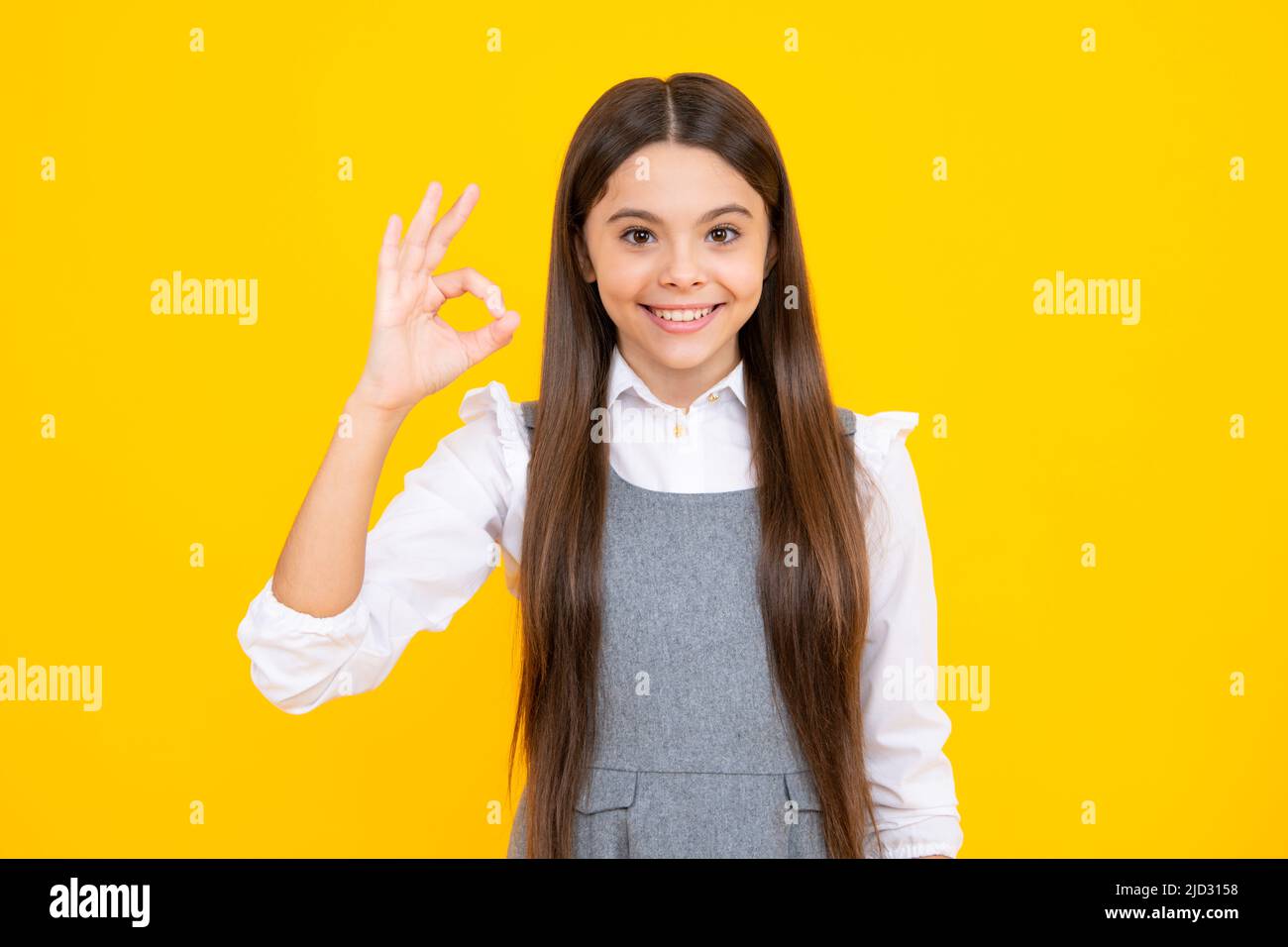Beautiful child girl making ok sign on yellow background. Portrait of ...