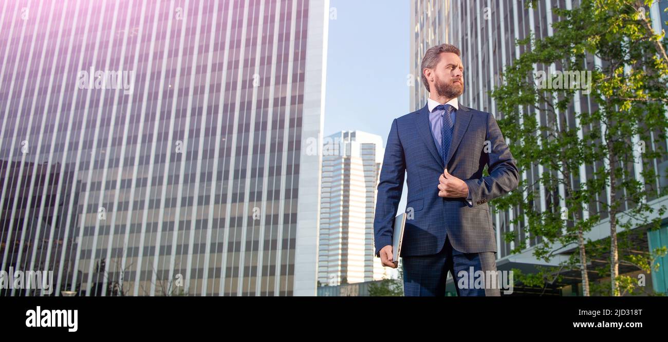 successful man in formalwear with computer outside the office ...