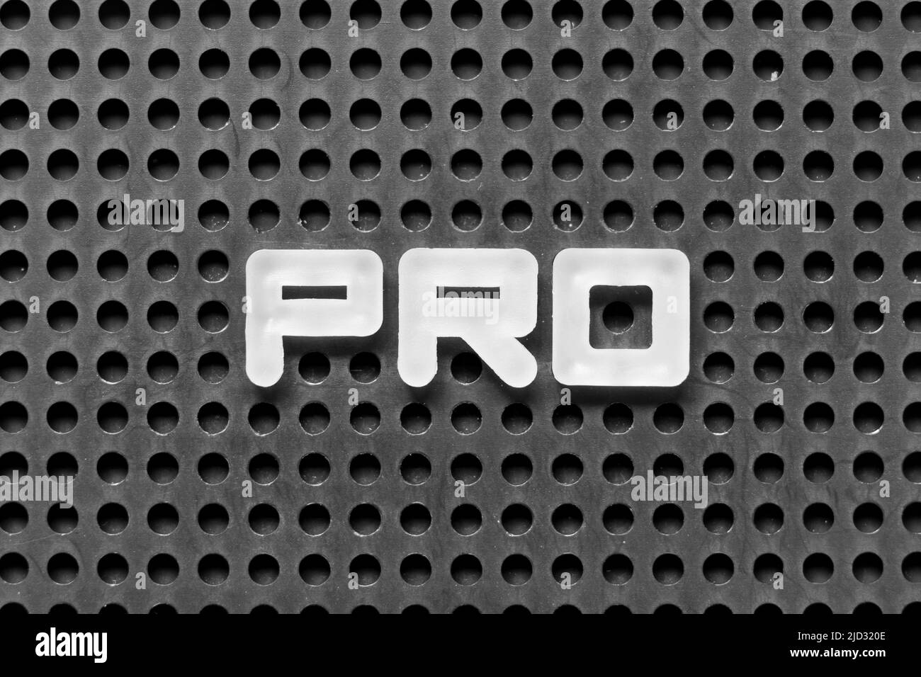 White alphabet letter in word pro on black pegboard background Stock ...