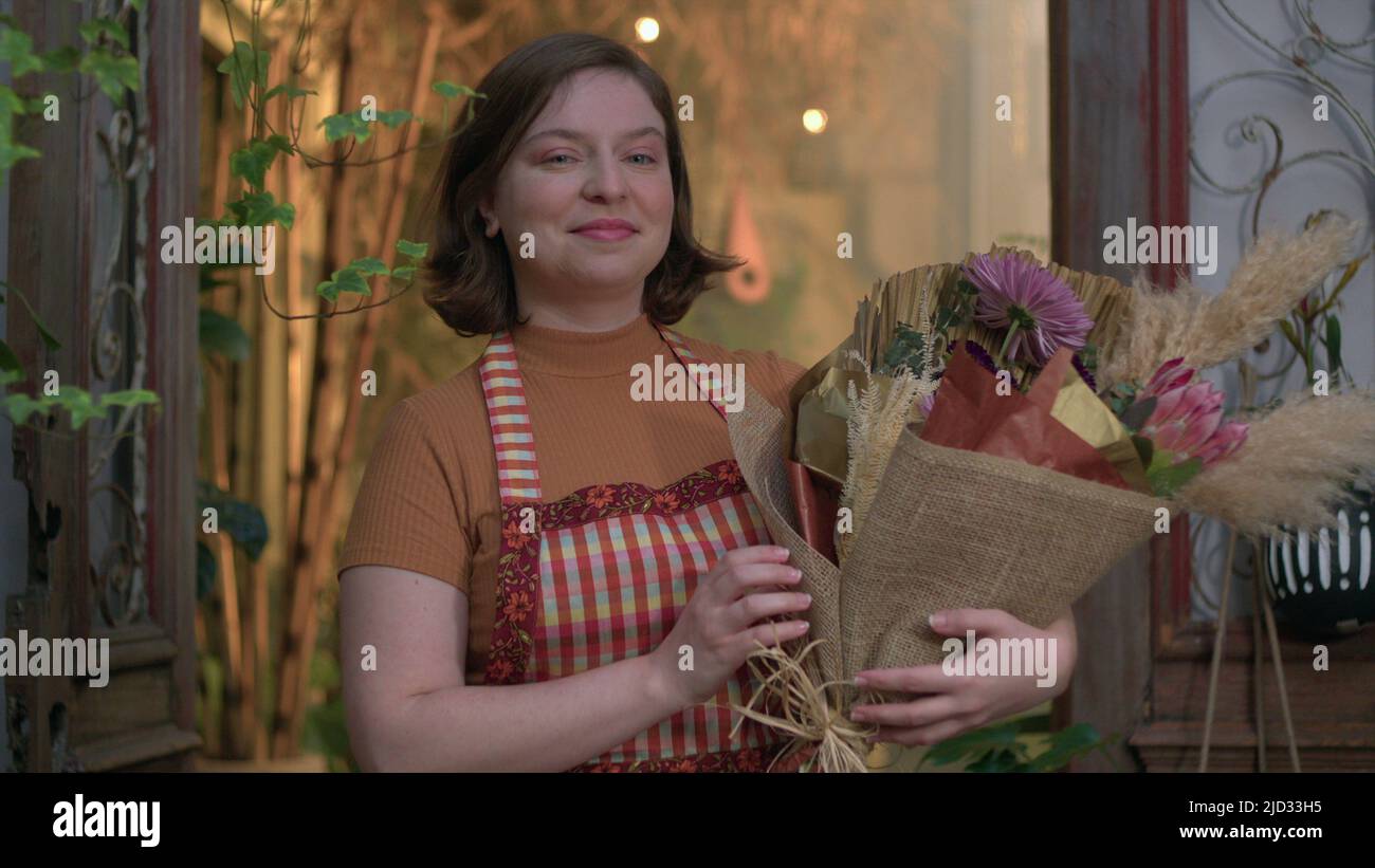Female employee holding beautiful bouquet of flowers inside flower ...