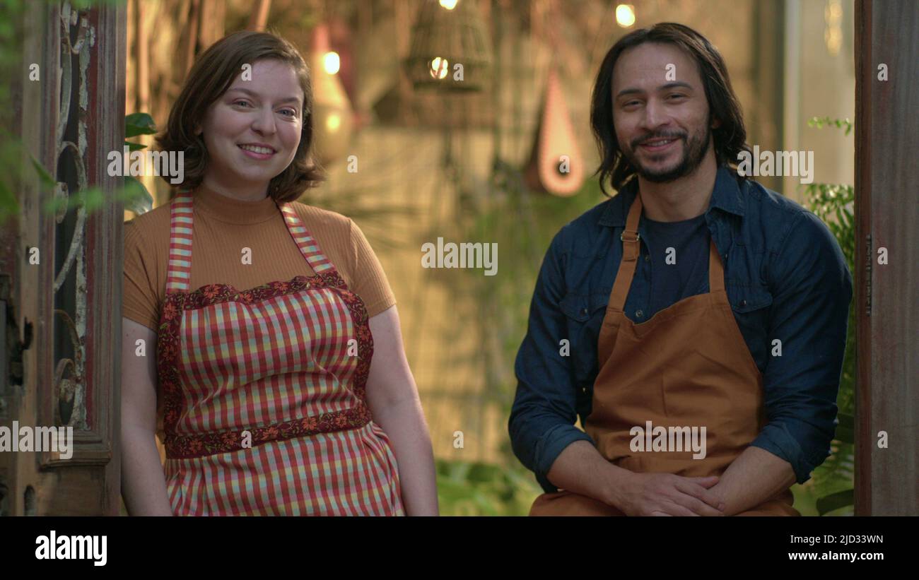 Portrait of two employees at flower shop wearing aprons smiling at ...